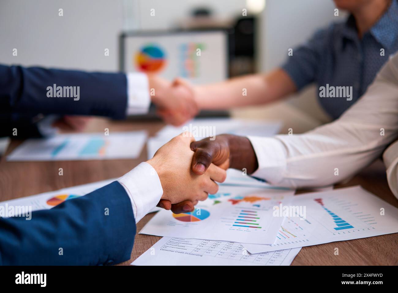 Multiracial business team conclude talks with handshake over financial ...