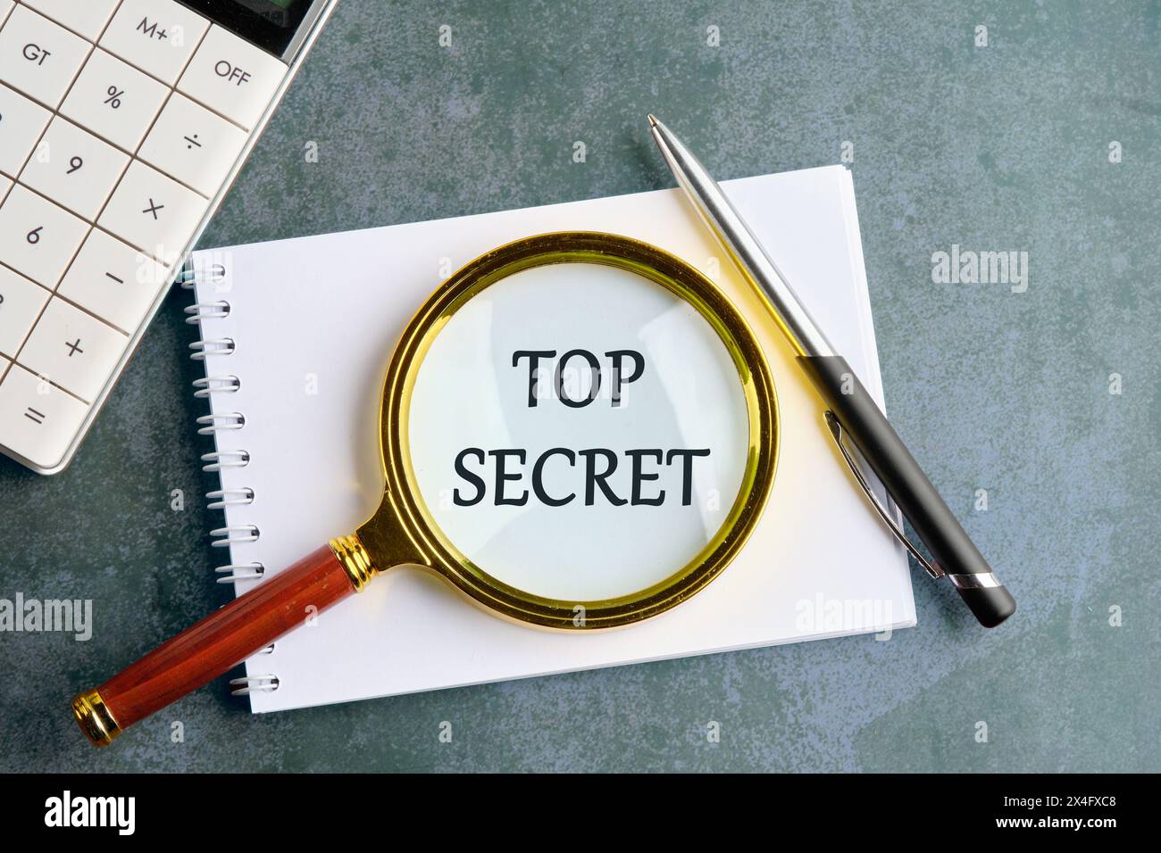 Top Secret text written through a magnifying glass on a notebook in a ...