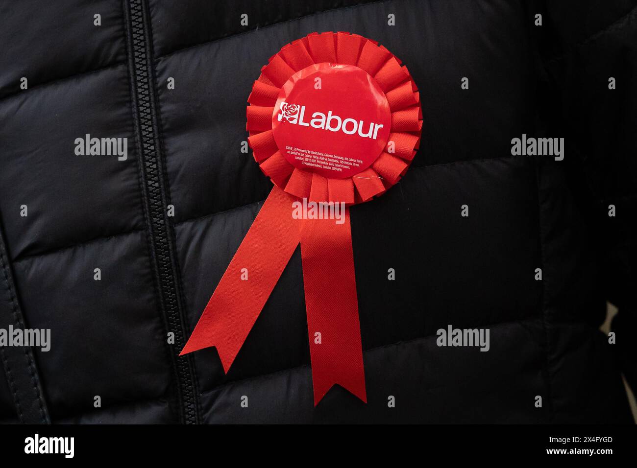 London, UK. 02nd May, 2024. A teller's red Labour Party rosette is seen ...