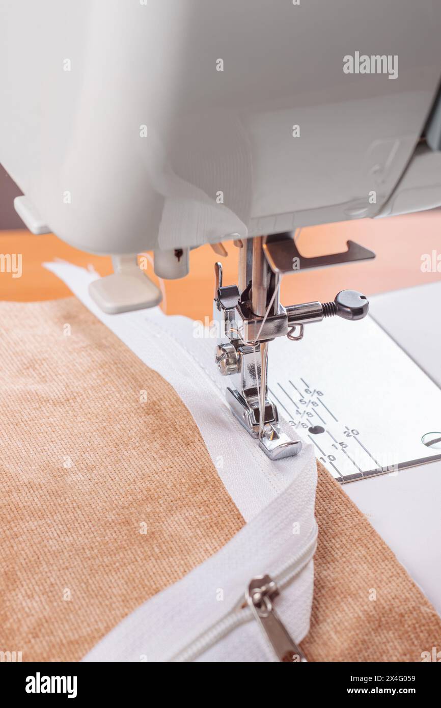 Modern sewing machine special presser foot with beige fabric and thread ...