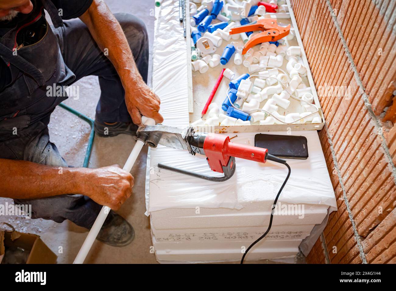 Plumber's hands as using handy power tool, iron for soldering, welding ...