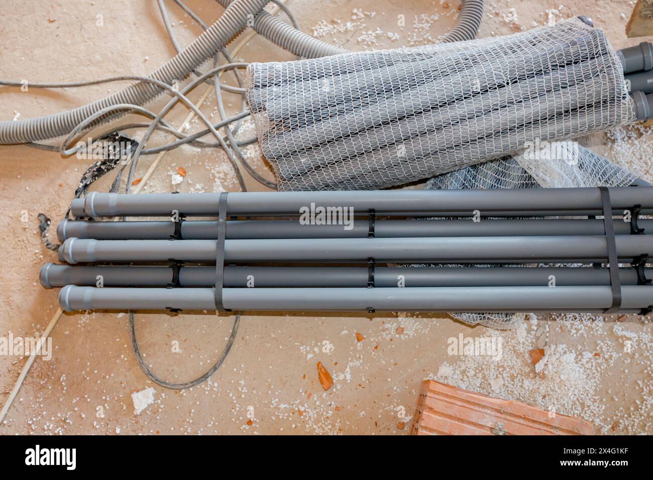 Package of new grey plumbing sewer pipes placed on the floor waiting to ...