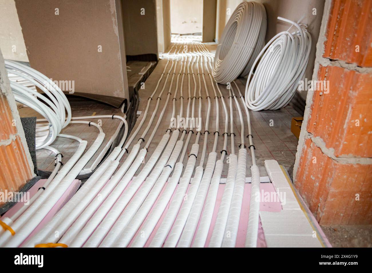 Low angle view on thin white tubes bended in complex curve of new brass ...