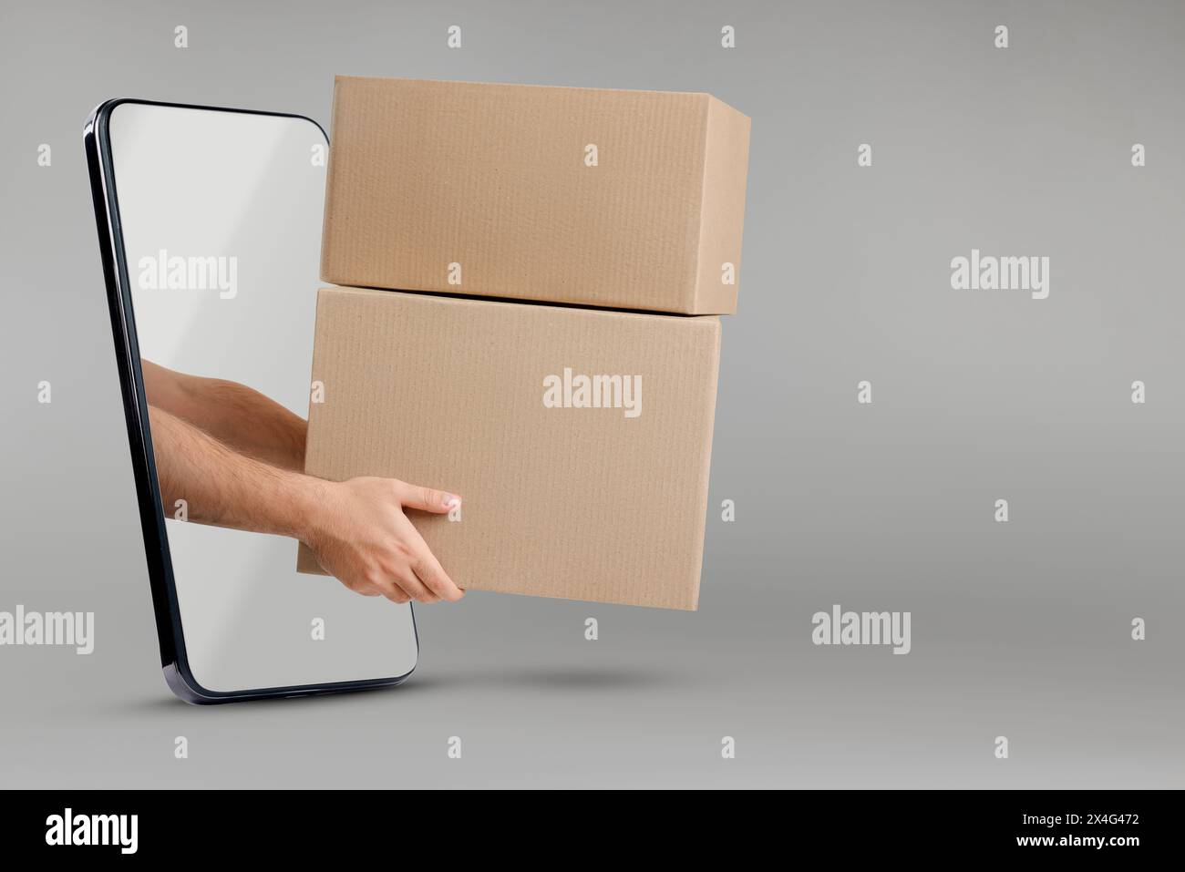 Courier passing parcels through smartphone on grey background. Delivery ...