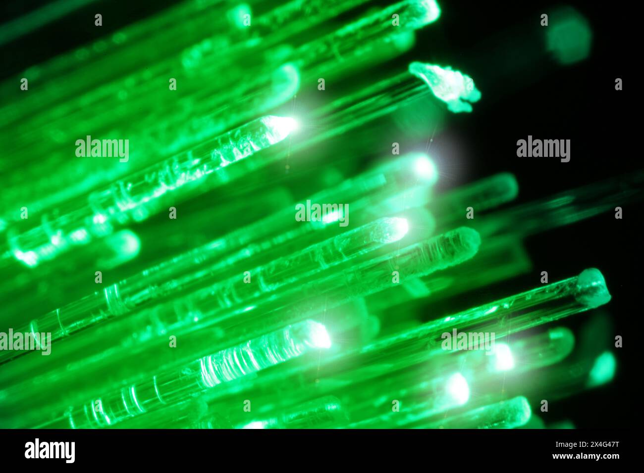 Optical fiber strands transmitting green light on black background ...
