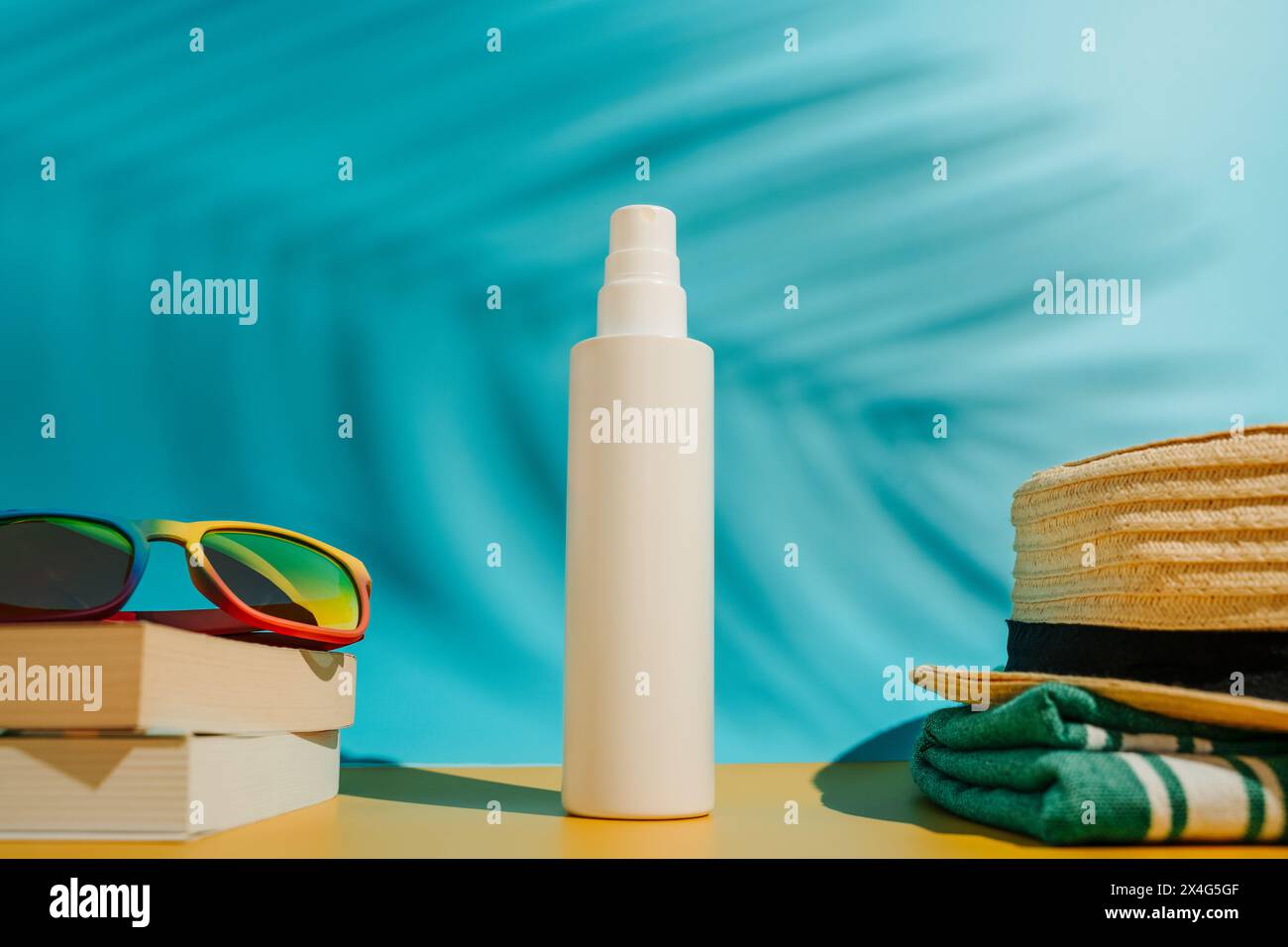 Blank white sunscreen bottle sun hat sunglasses and books on beach in ...