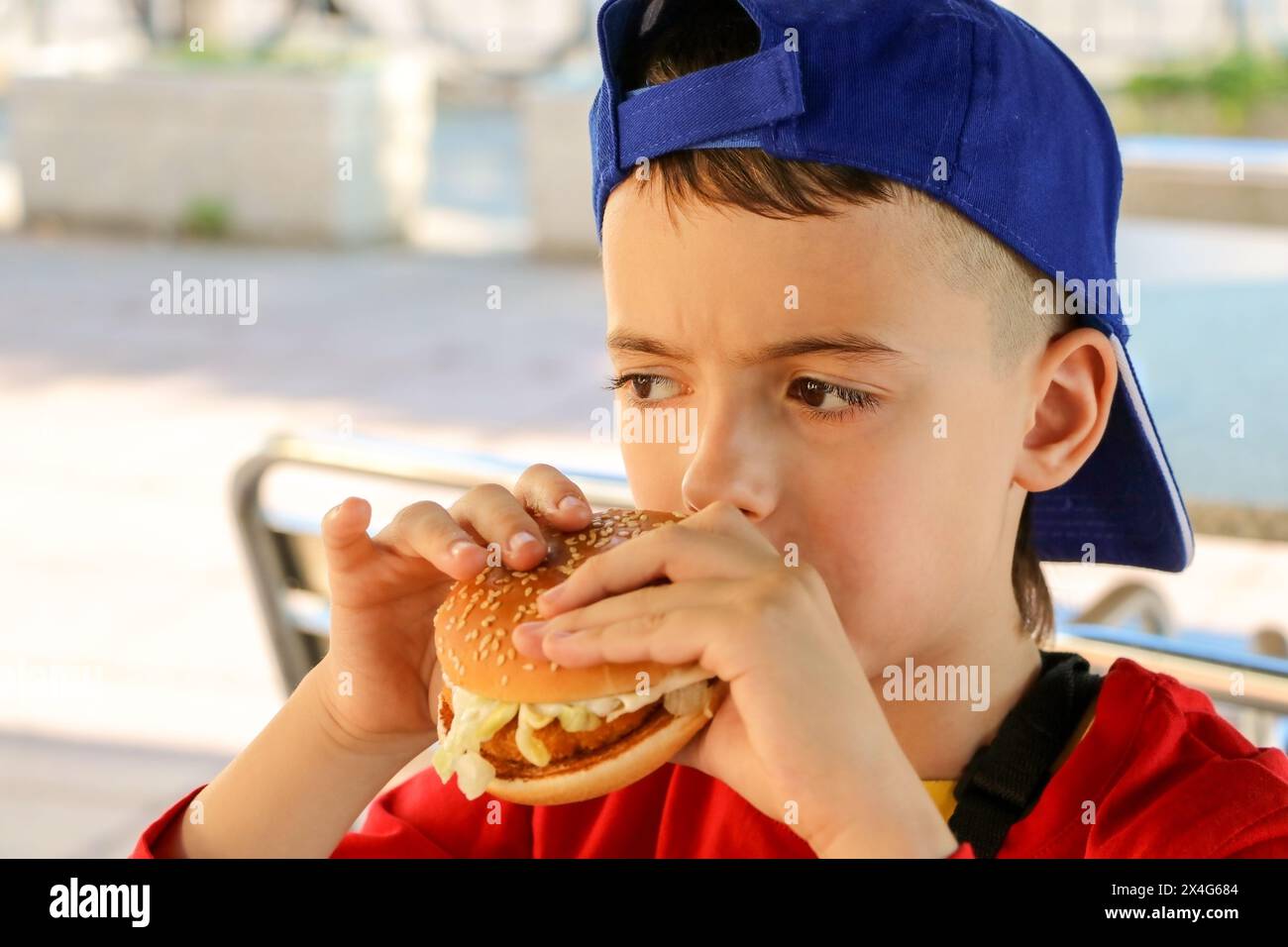 Hungry child eating fast food Stock Photo - Alamy