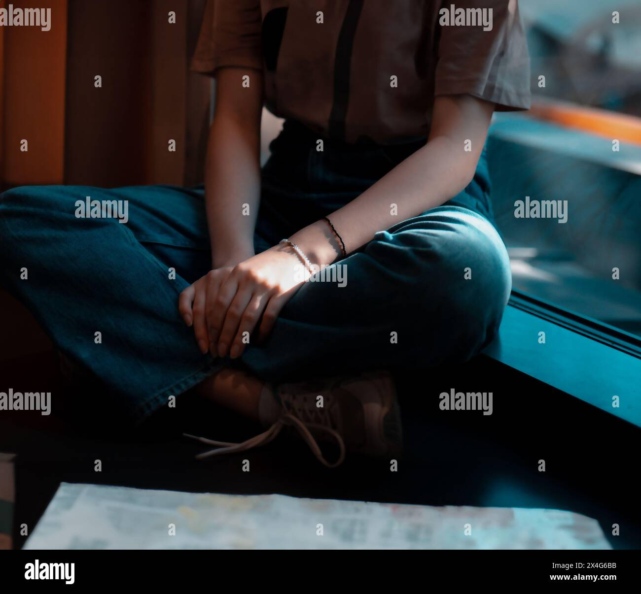 Middle section of teenage body sitting on the floor Stock Photo - Alamy