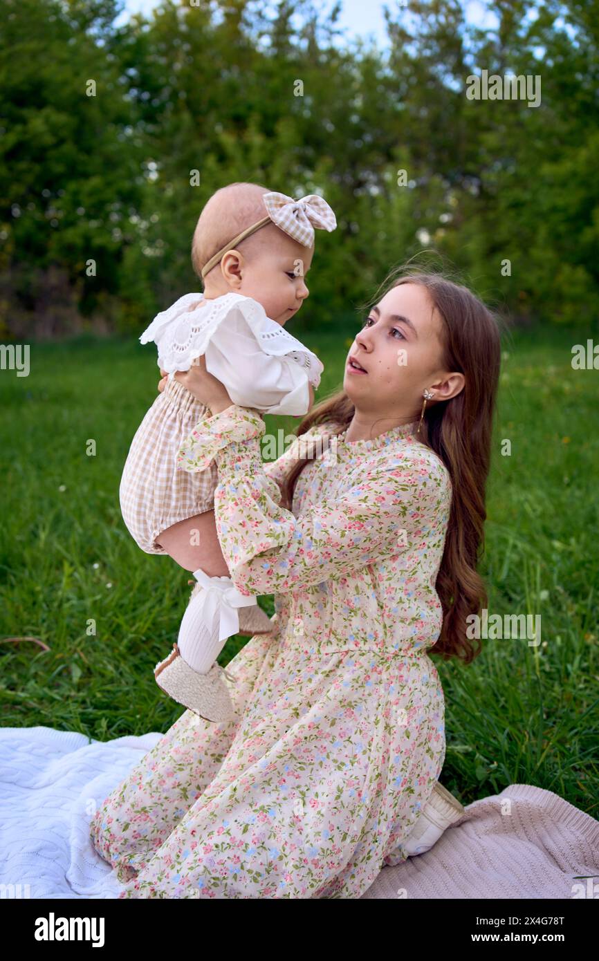 the sisters of different ages hug each other tenderly on a picnic in ...