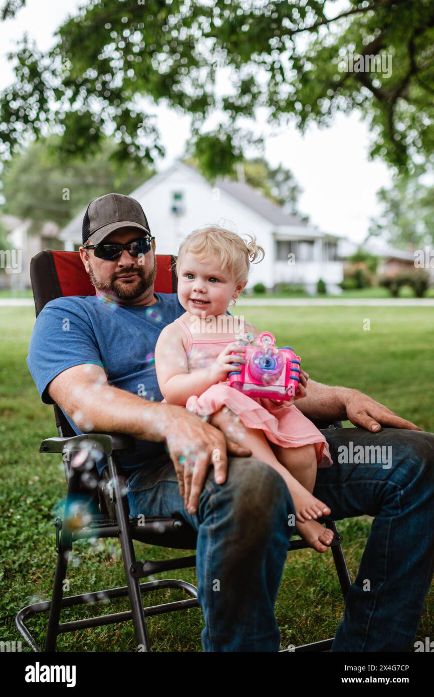 Dad and daugther at family gathering playing with bubble camera Stock ...
