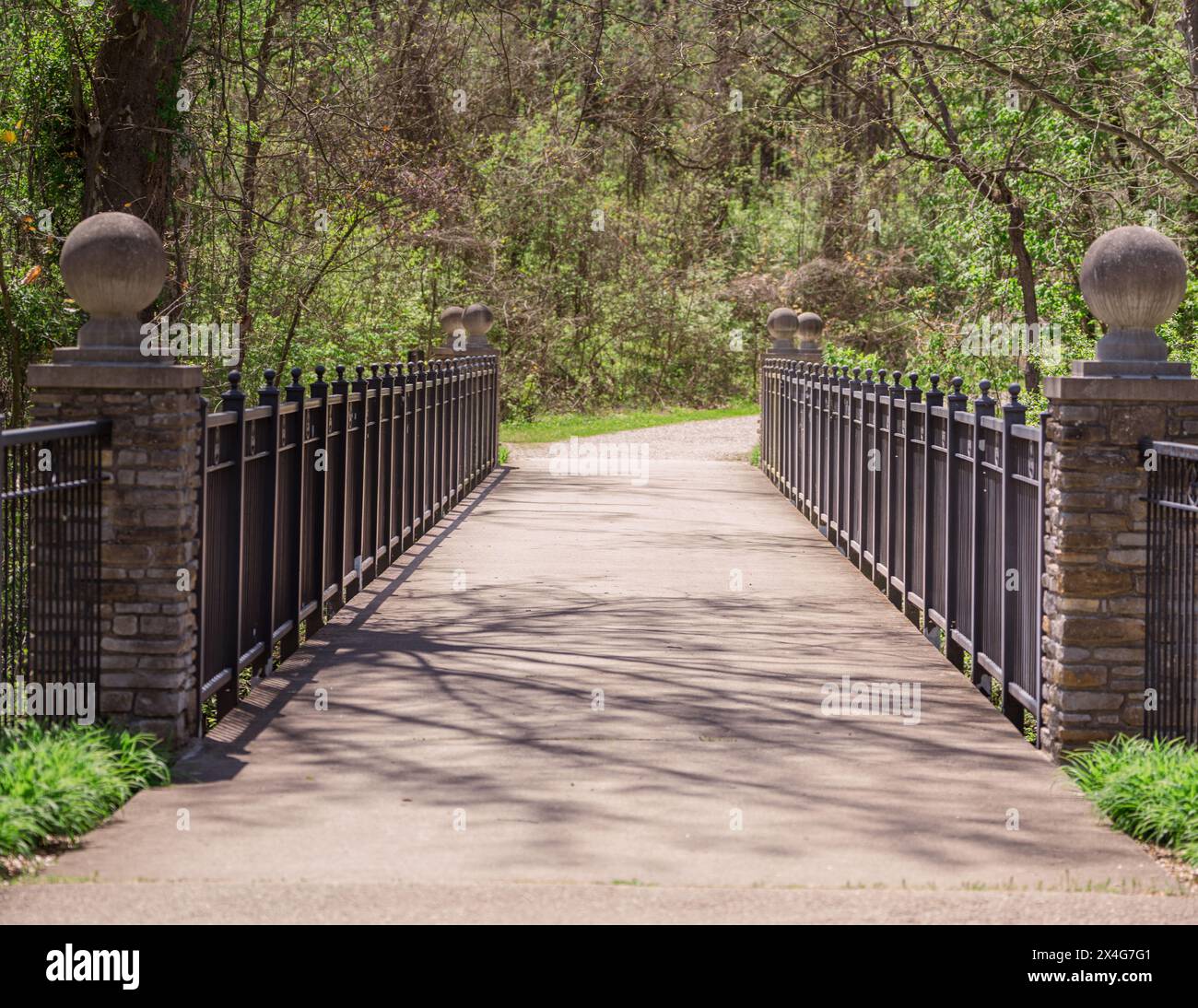 A concrete pathway with iron railings over a creek Stock Photo - Alamy
