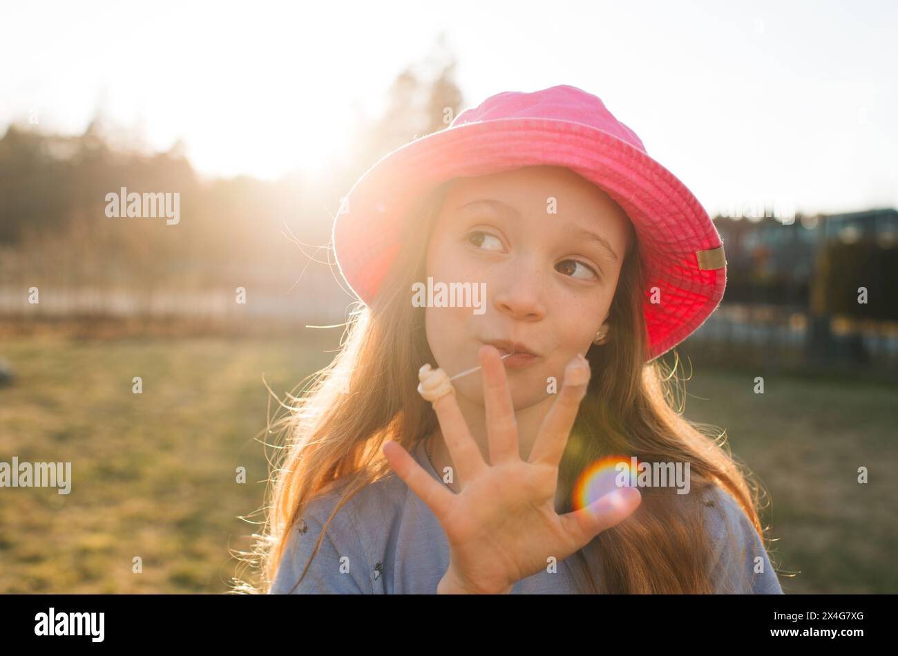 girl making faces with bubblegum at sunset Stock Photo - Alamy