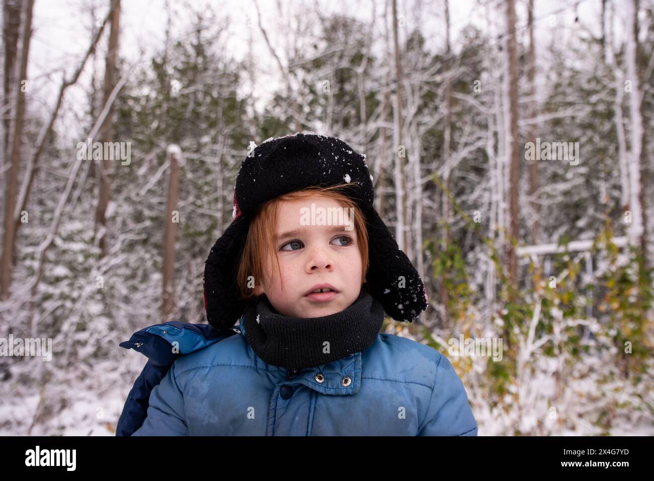 Boy with long red hair wear a toque in front of a snowy forest Stock ...