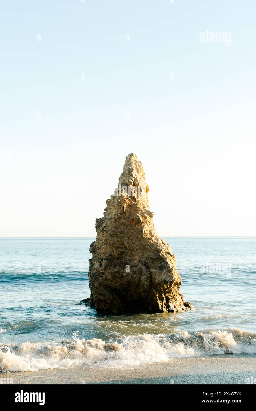 Solitary rock formation rising from ocean waves Stock Photo - Alamy