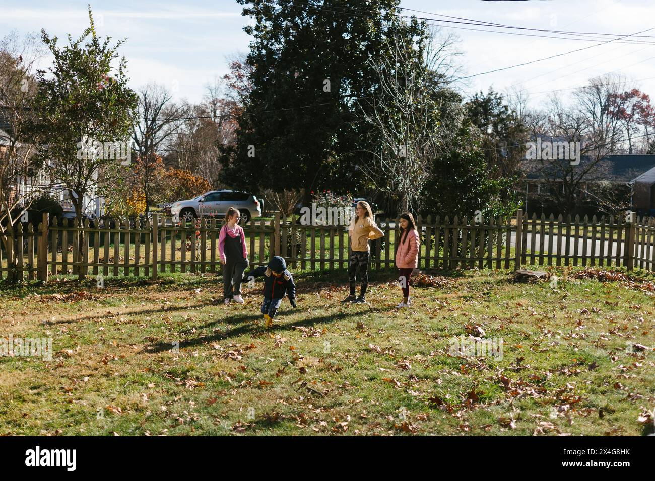 Group of kids play outside in front yard together in fall Stock Photo ...