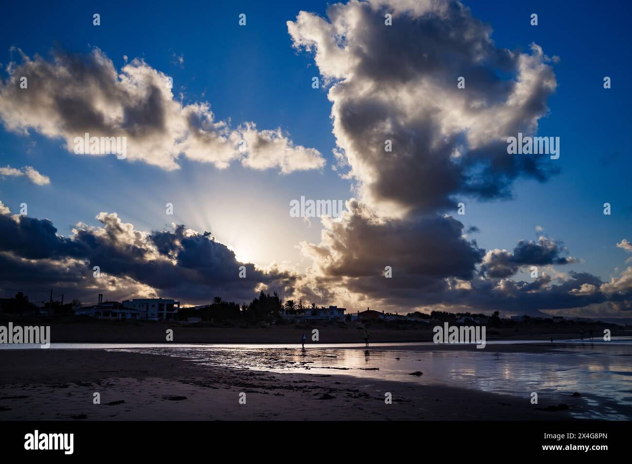 Veiled sun on the beach of Oliva Stock Photo - Alamy