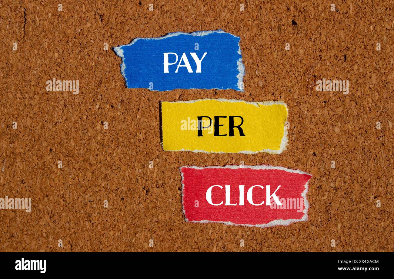 Pay per click words written on ripped paper pieces with brown ...