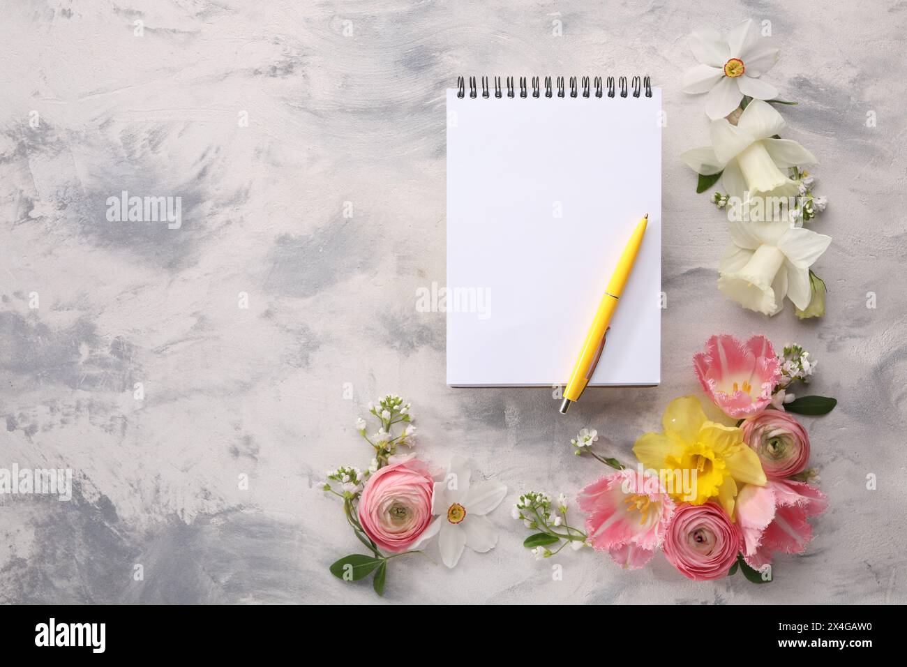 Guest list. Notebook, pen and beautiful flowers on gray textured ...