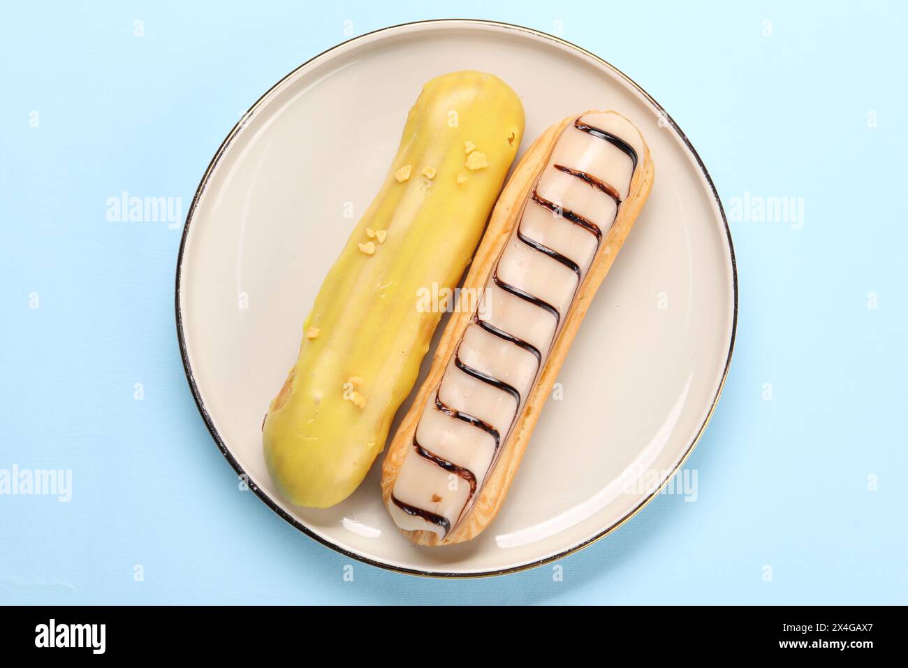 Delicious eclairs covered with glaze on light blue background, top view ...