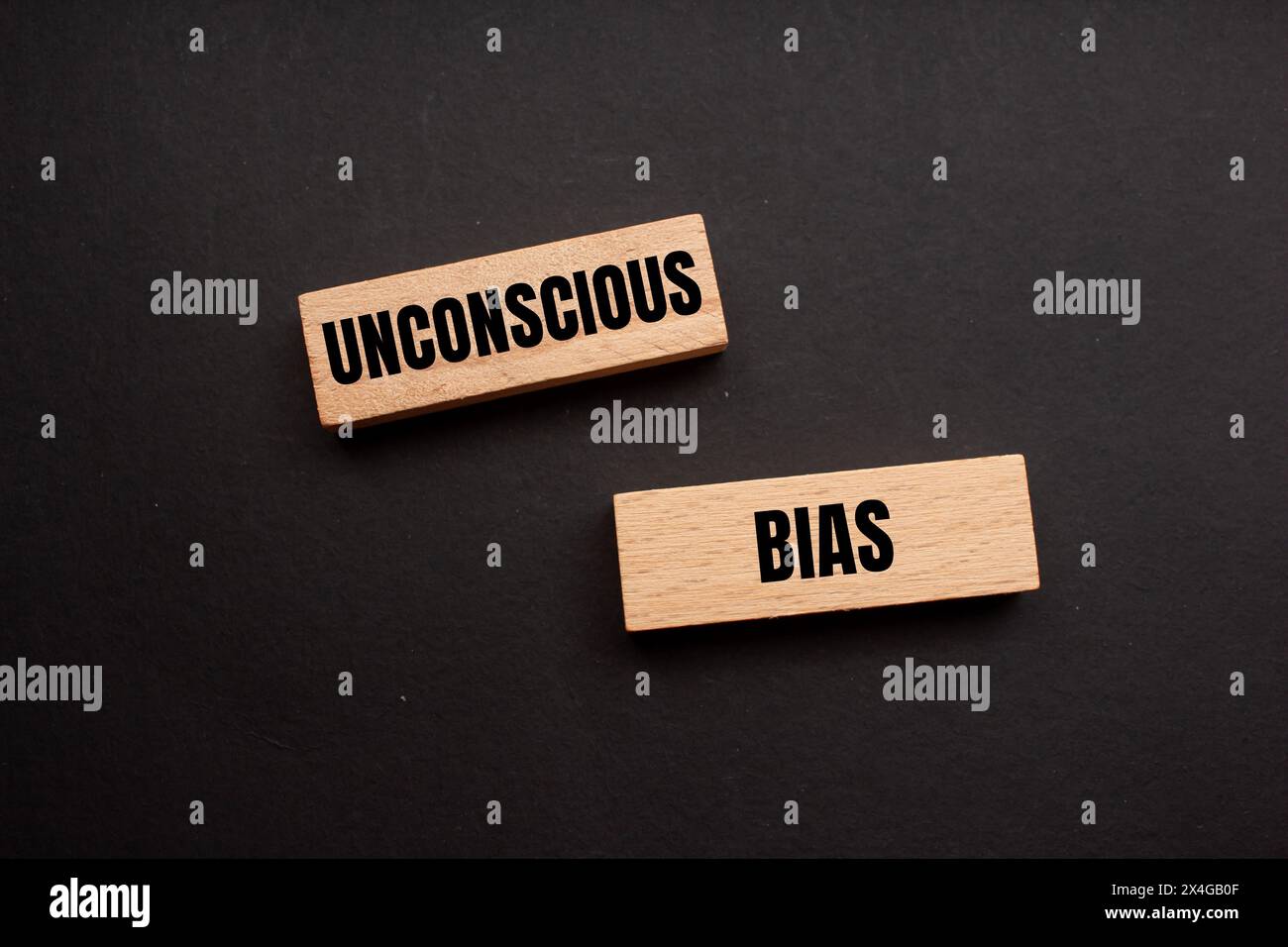 Unconscious bias words written on wooden blocks with black background ...