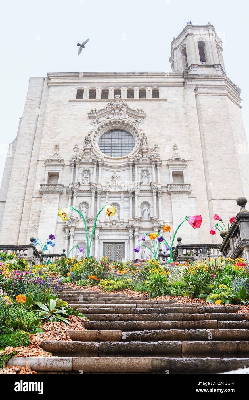 A church with a colorful flower garden on the steps leading up to it ...