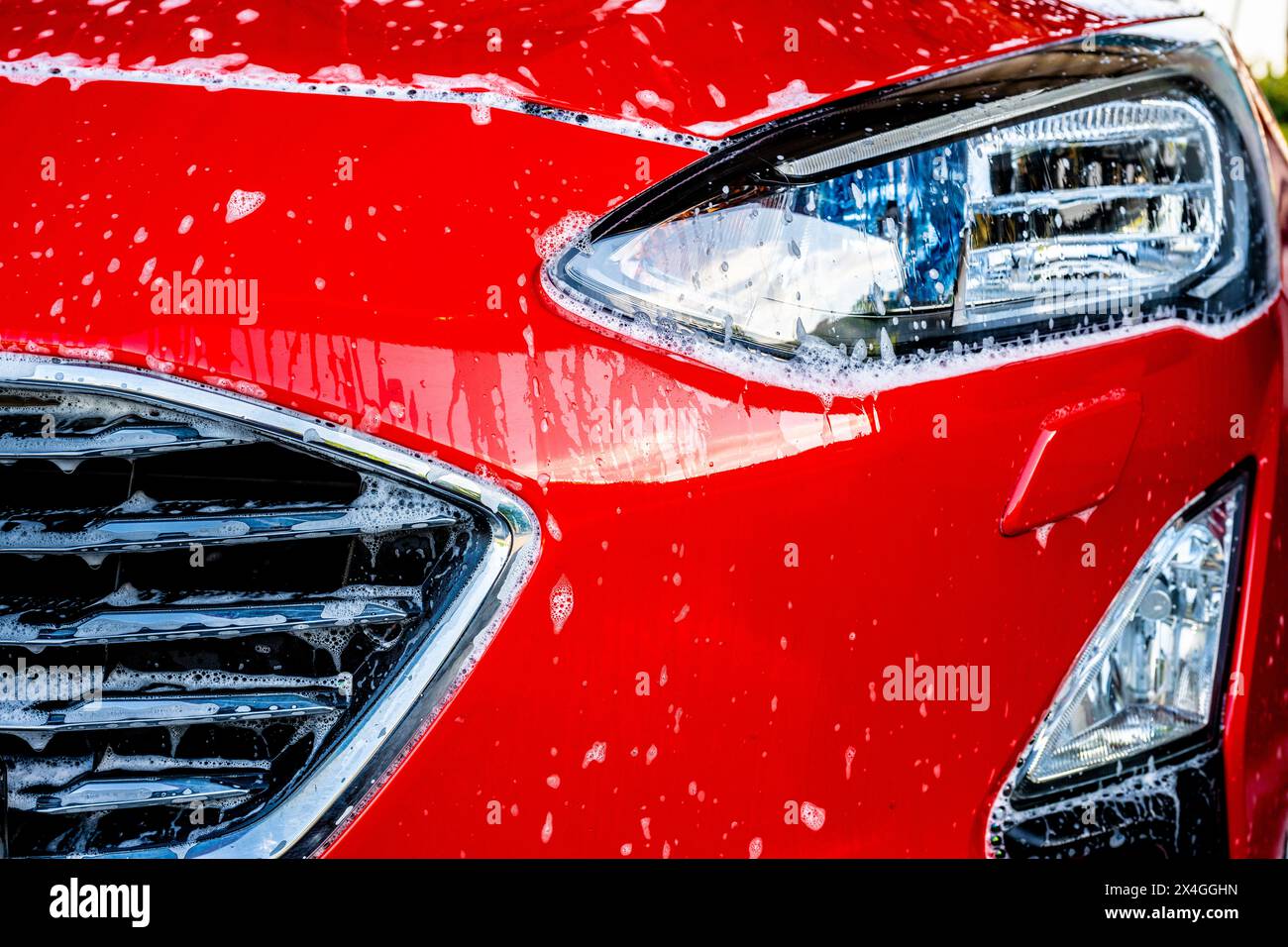 Front headlight and grille of a red car being washed Stock Photo - Alamy