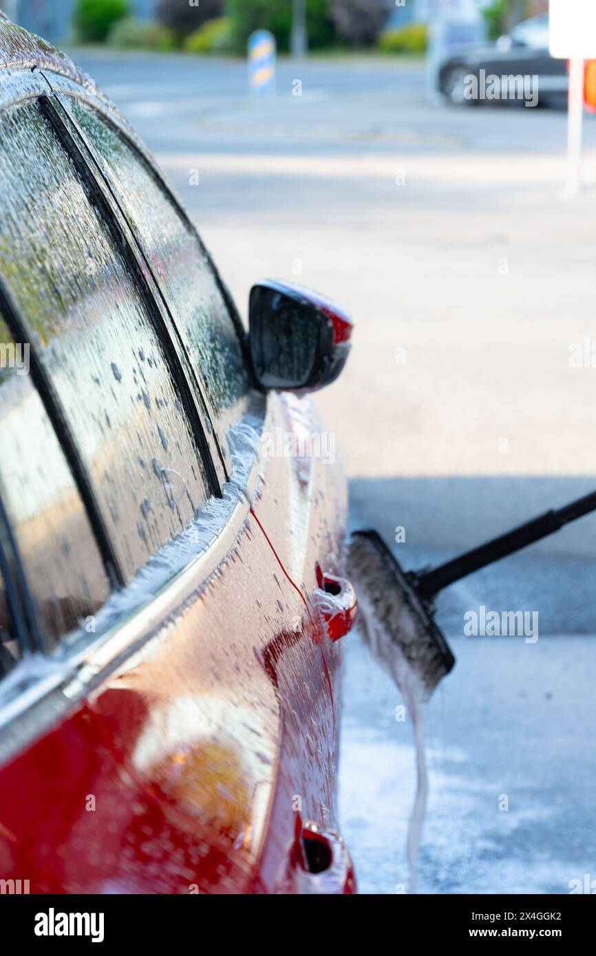 Side of a red car at a car wash Stock Photo - Alamy
