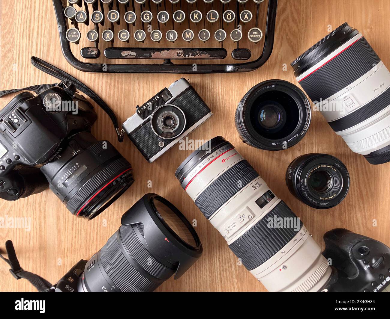 Old and new cameras on a desk with a typewriter Stock Photo - Alamy