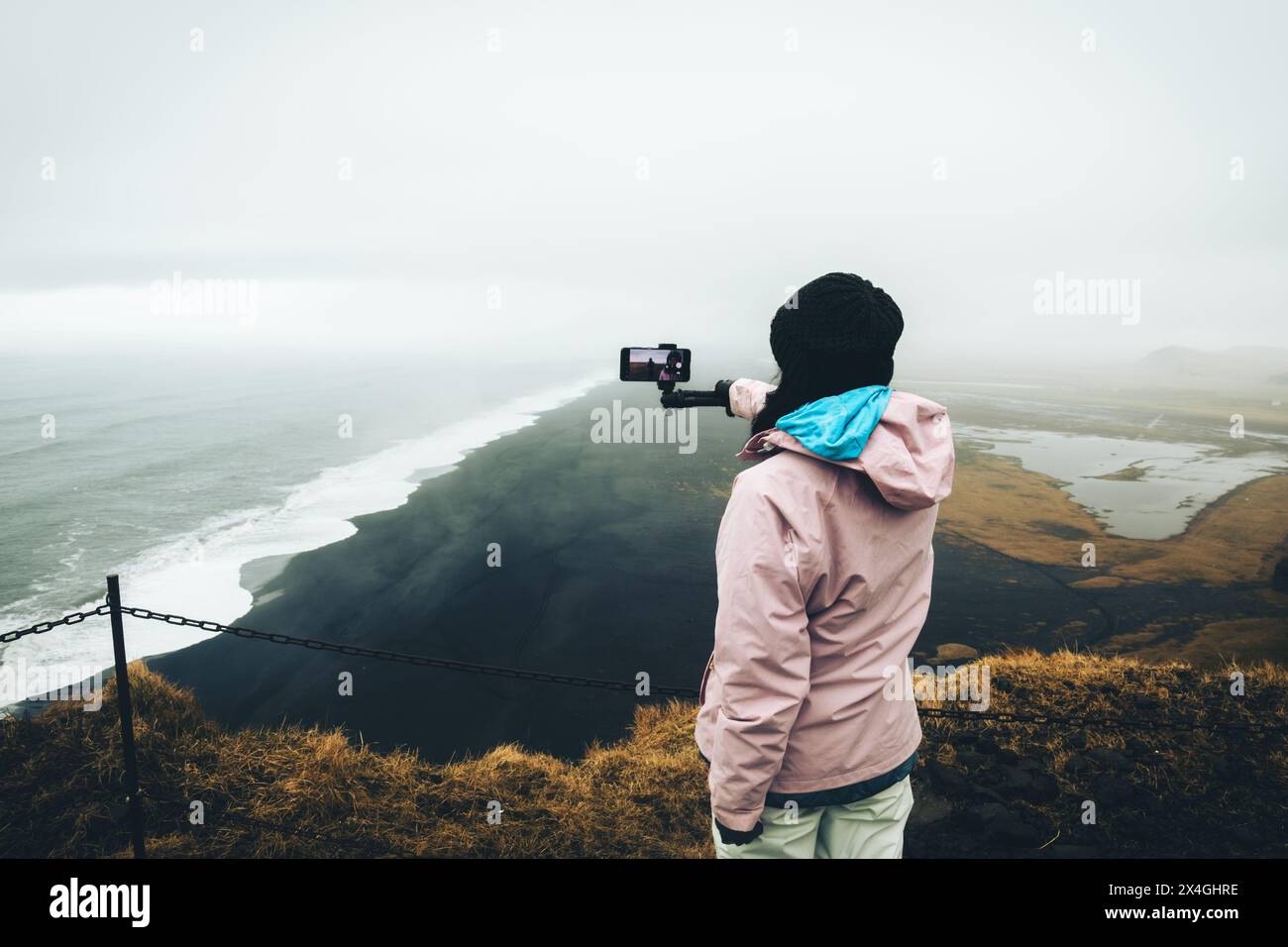 Woman tourist visit sightseeing black sand beach popular viewpoint hold ...