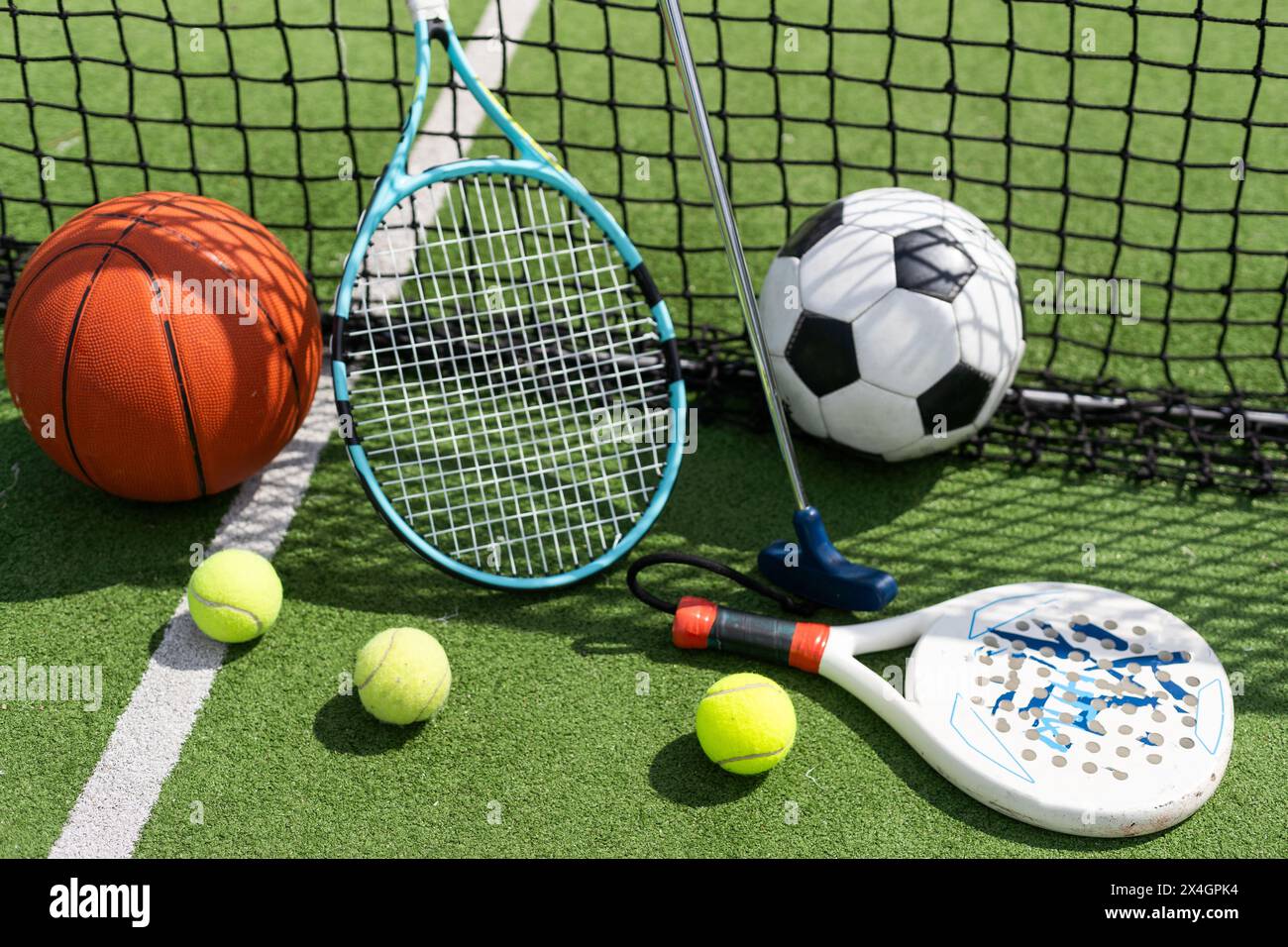 A variety of sports equipment including an american football, a soccer ...
