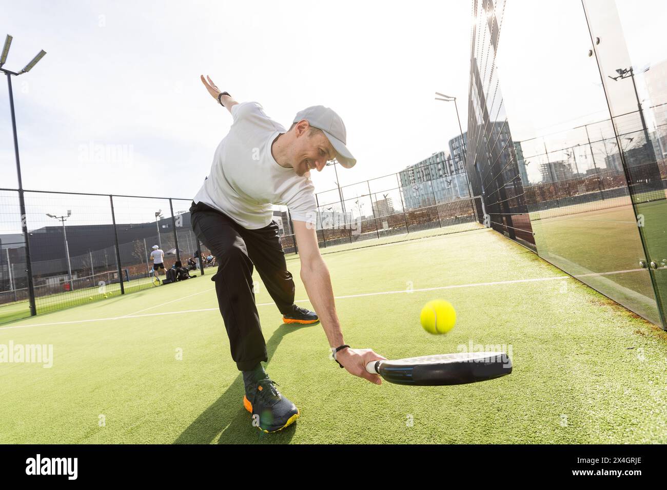 European man holding padel racquet in hand and ready to return ball ...