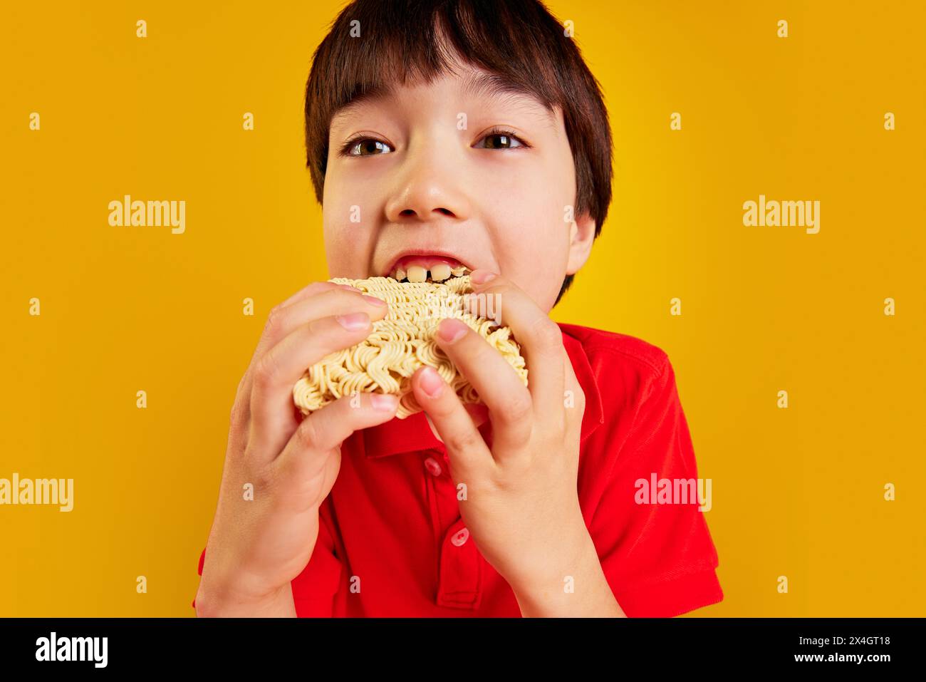 Young boy, child in a red polo shirt enjoying noodles, eating with his ...