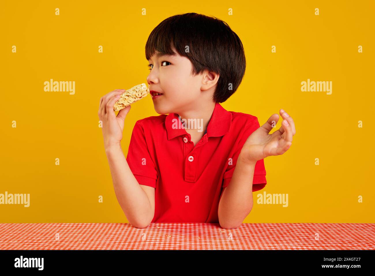 Korean boy in red polo shirt sitting at table and eating instant ...