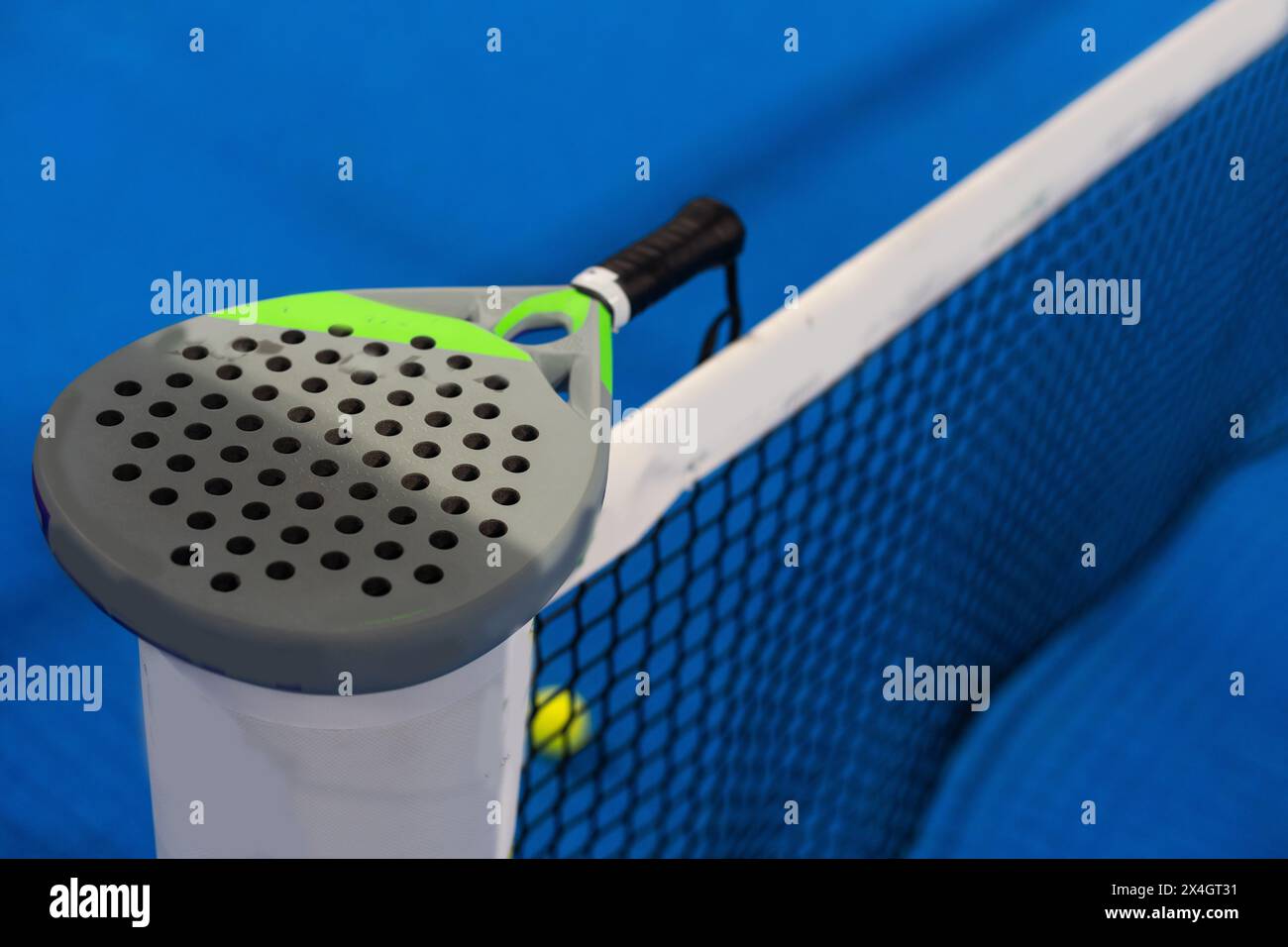 Twoo balls next to the net of a blue paddle tennis court. Sport healthy ...