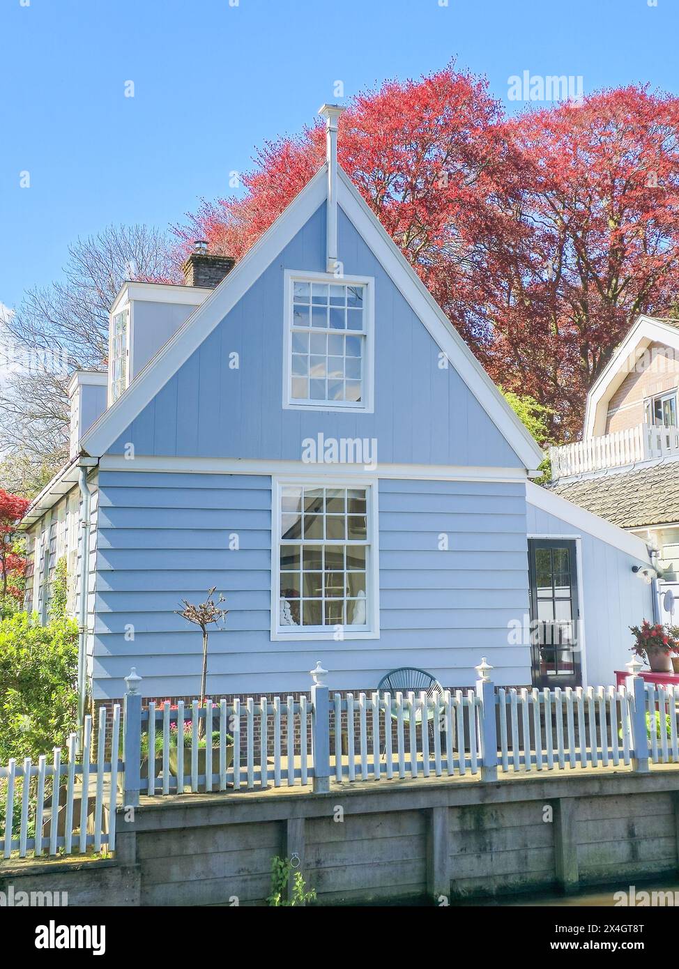 A charming blue house with a white picket fence standing peacefully ...