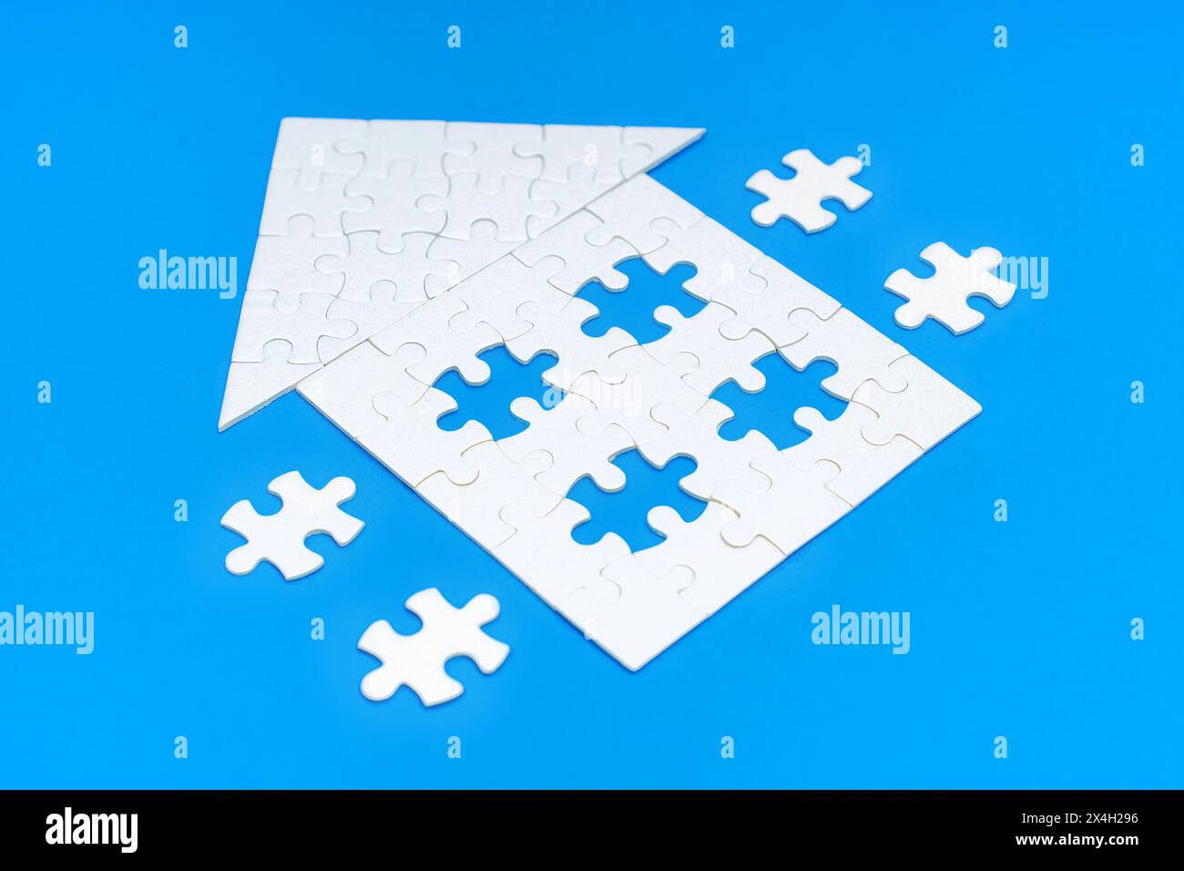 White house made up of interlocking jigsaw puzzle pieces set on blue ...