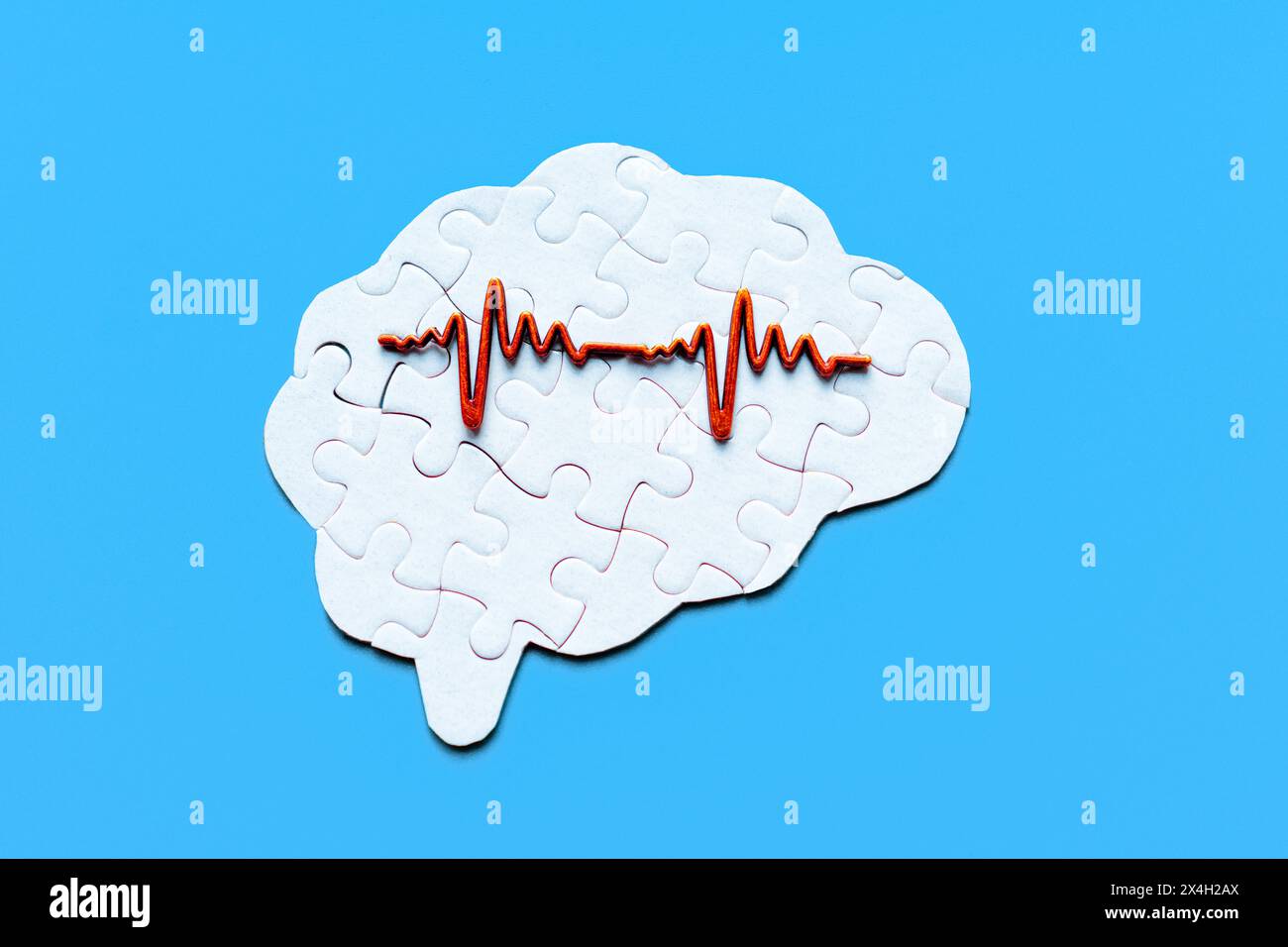 Human brain-shaped puzzle overlaid with an electroencephalogram (EEG ...