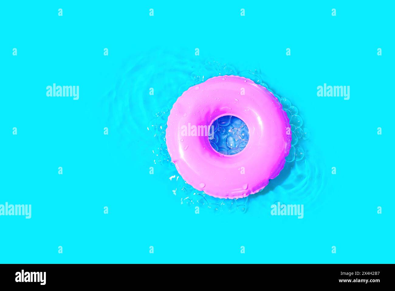 Top view of a purple swim ring floating in a clear pool. Summer ...
