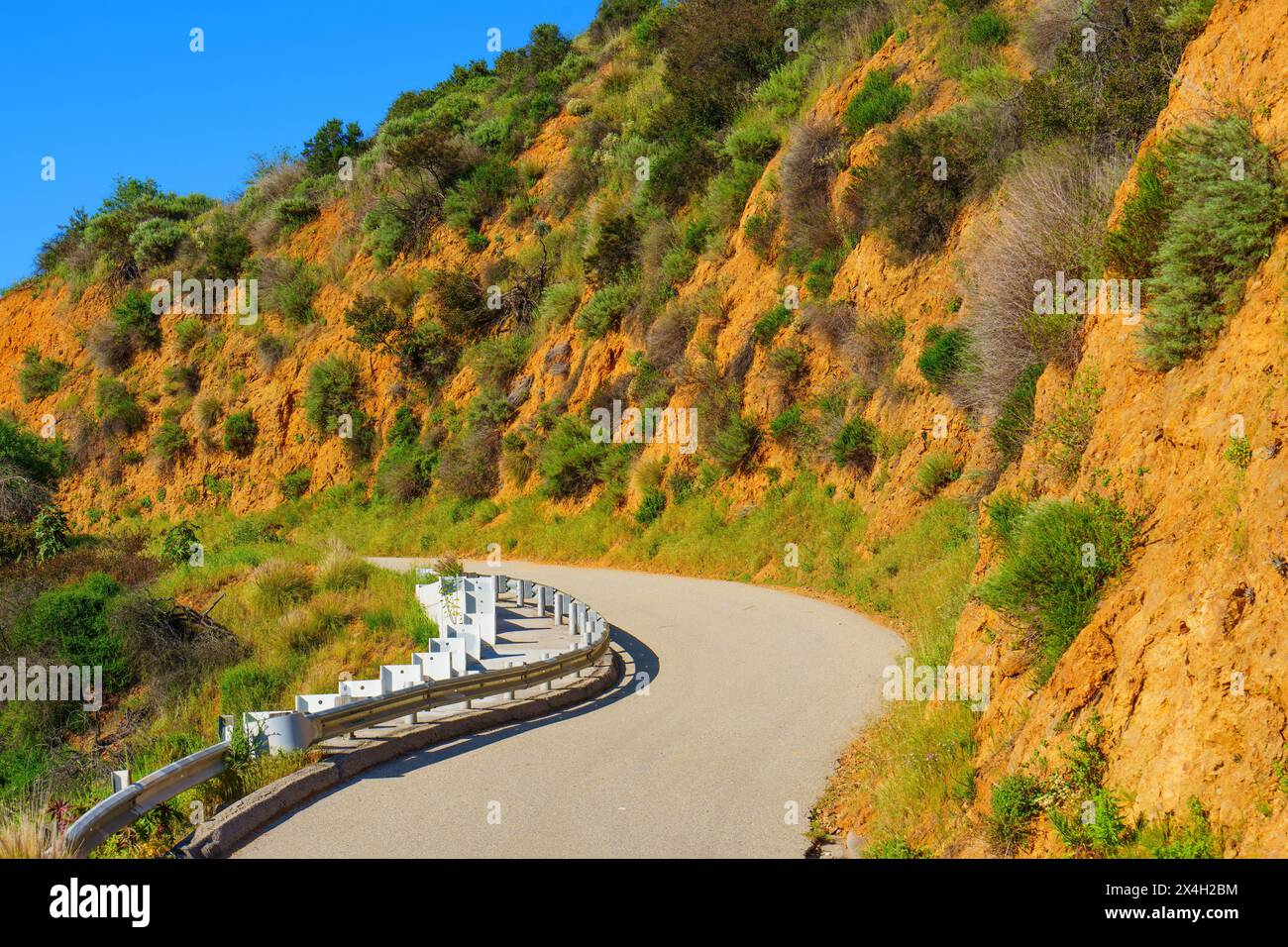 Winding asphalt road with a guardrail along the hillside in Hollywood ...