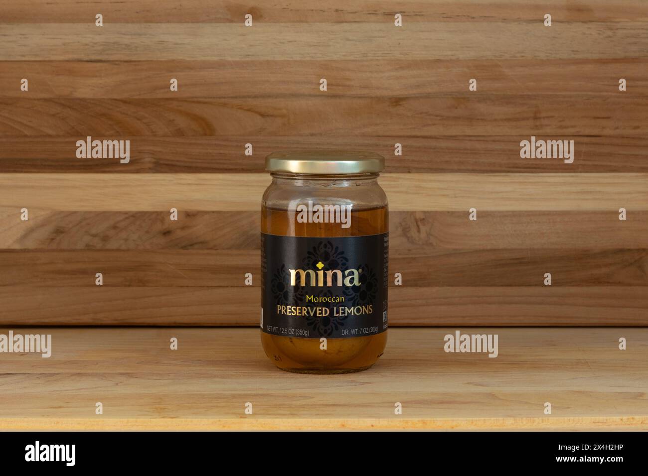 jar of Mina brand Moroccan preserved lemons on a rustic wood background ...