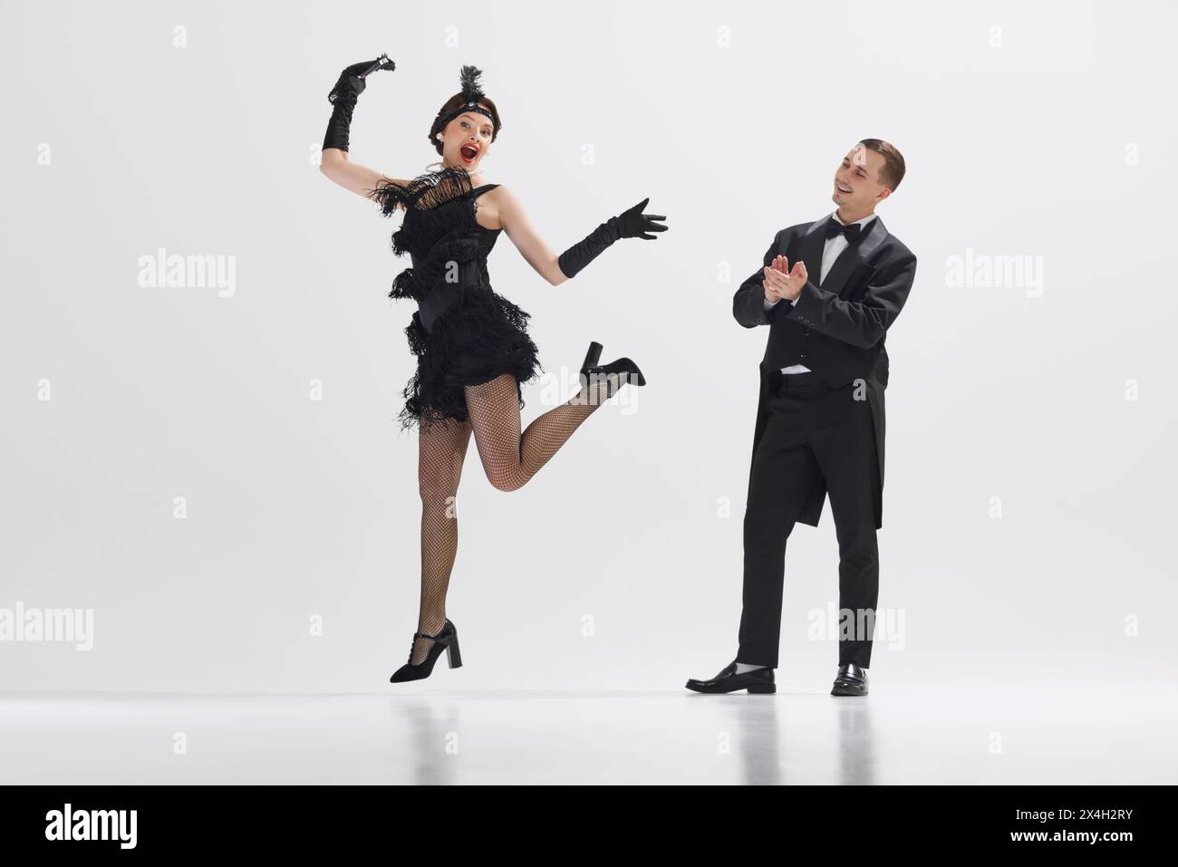 Handsome man looking at beautiful woman dancing and clapping with ...