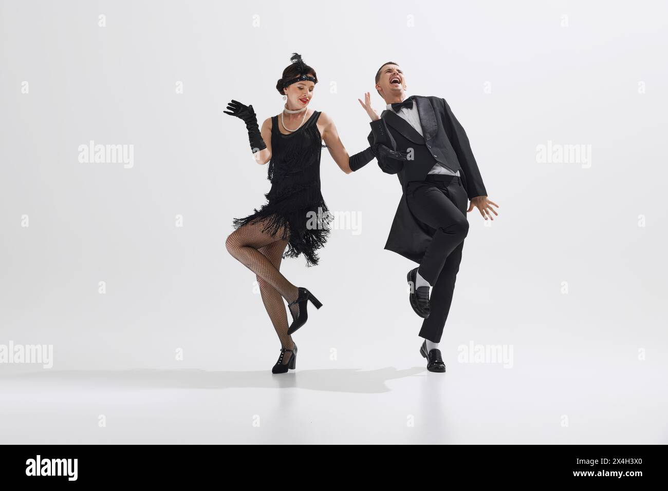 Woman in black flapper dress dancing with man in classic black suit ...