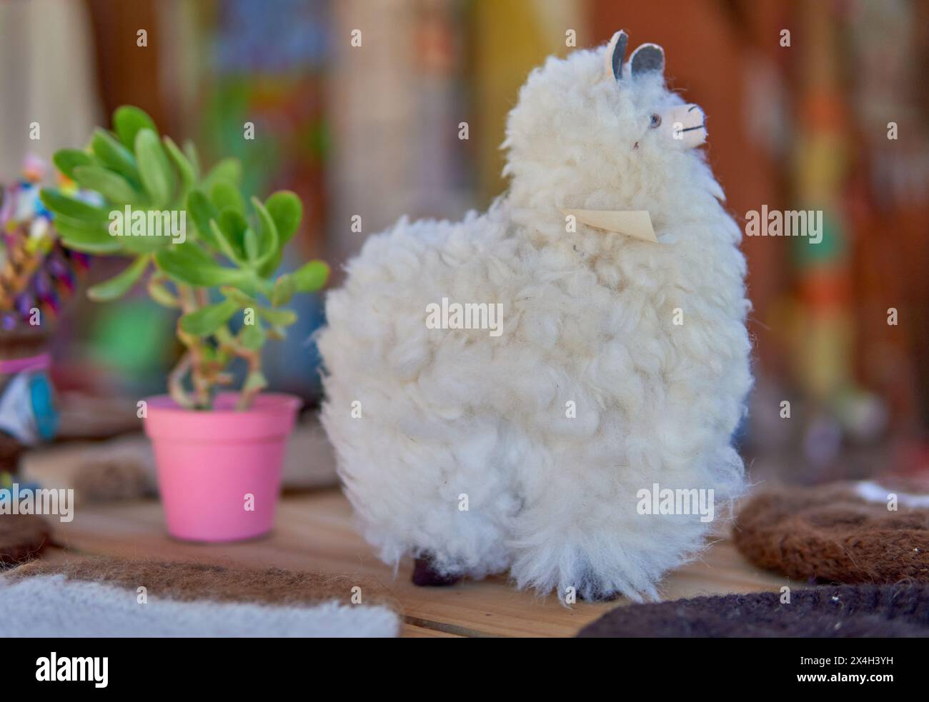 handmade souvenir doll of a small white stuffed llama and a plant ...