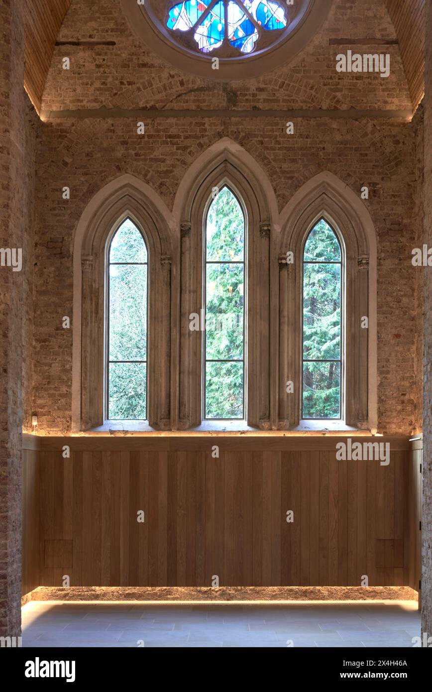 Arched gothic window with view to cemetery. Abney Park Chapel, London ...