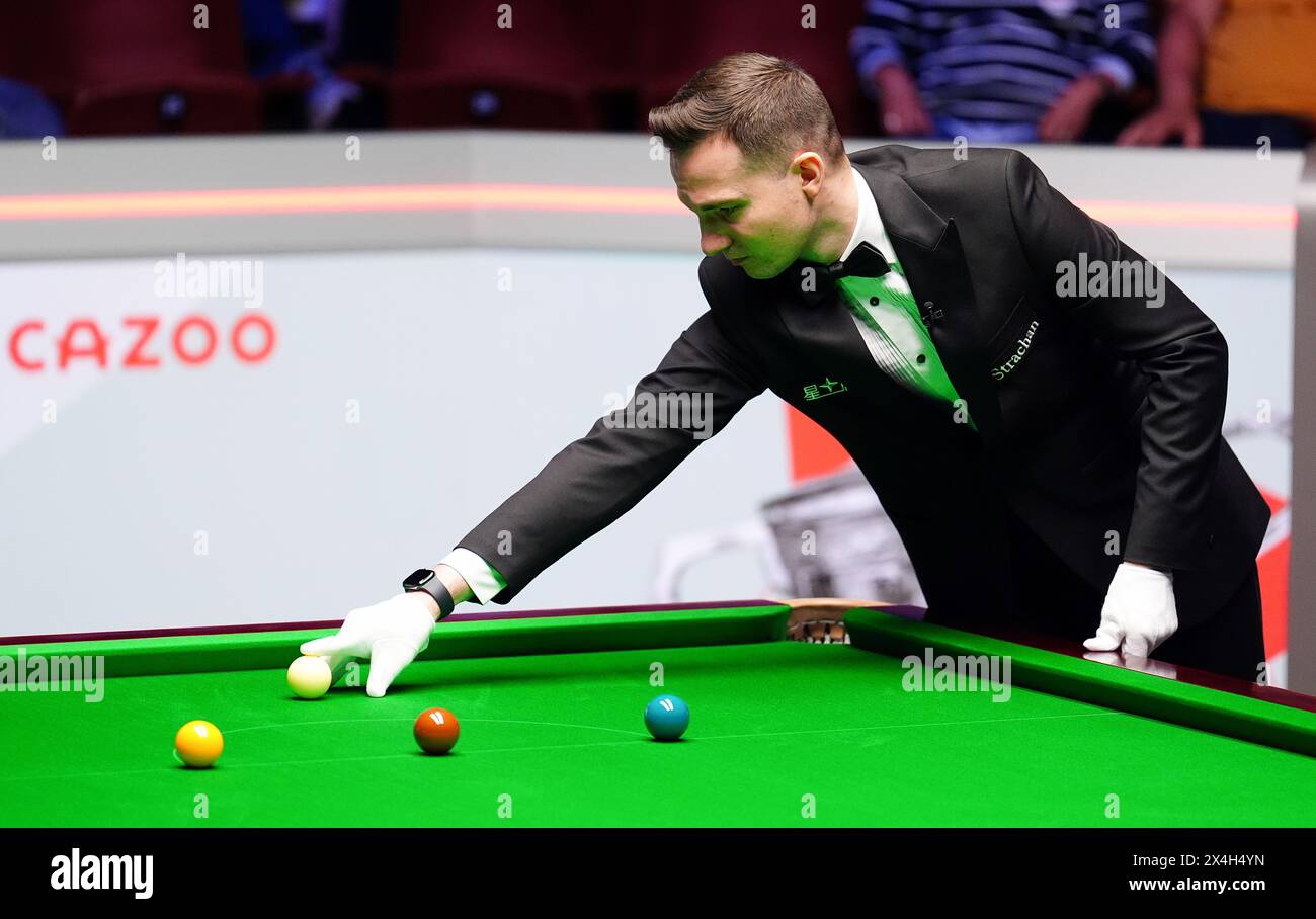Snooker referee Marcel Eckardt positions the white ball on day fourteen ...