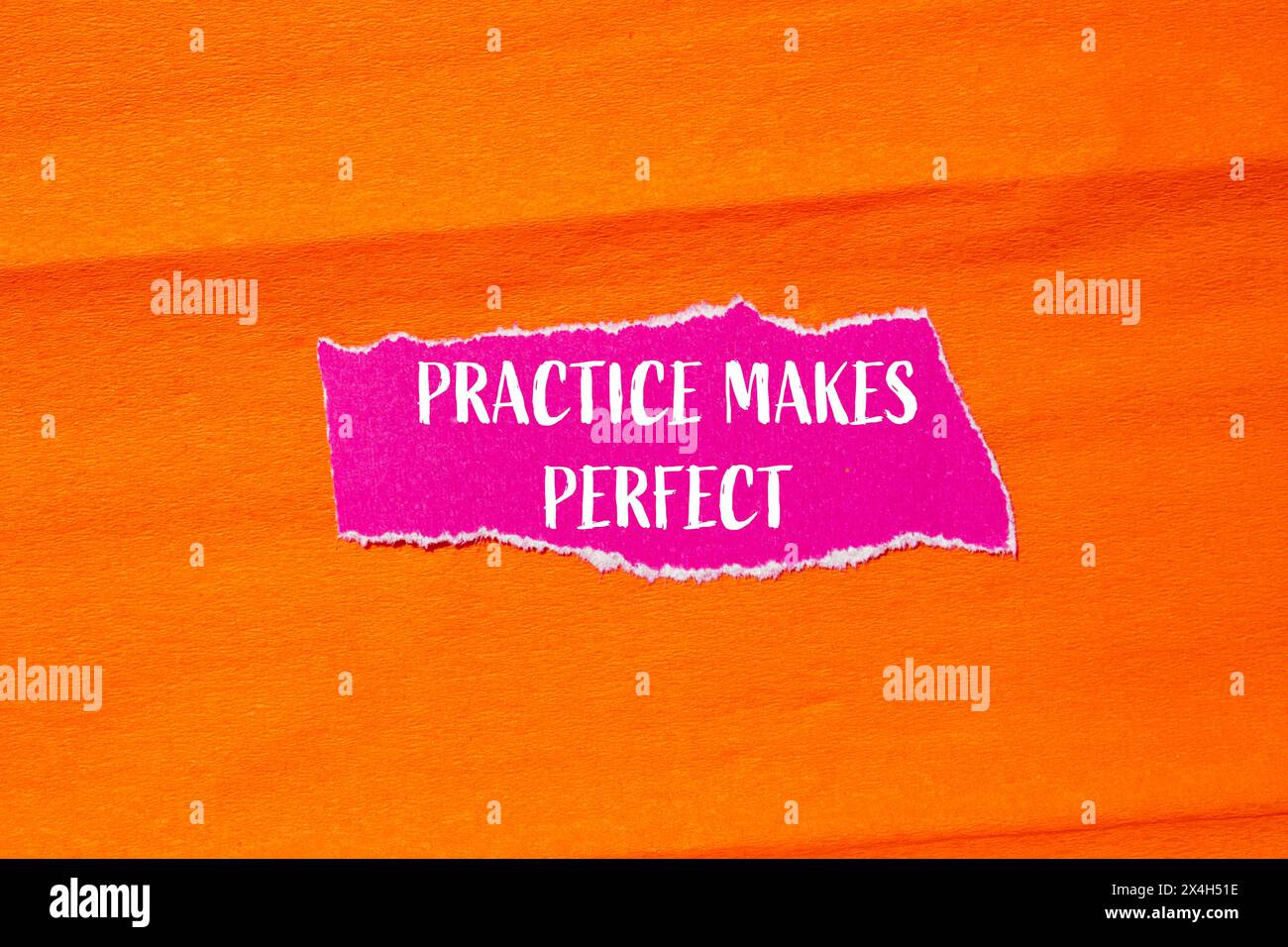 Practice makes perfect words written on ripped pink paper piece with ...