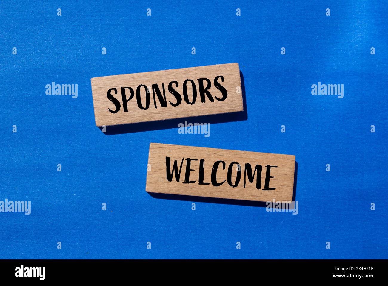 Sponsors welcome words written on wooden blocks with blue background ...