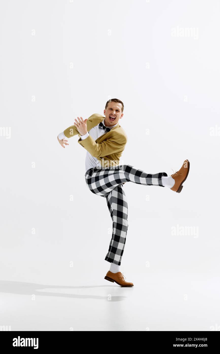Joyful male performer in stylish outfit with checkered pants and jacket ...