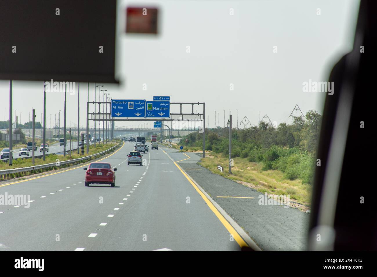 Driving on a multi-lane highway in Al Ain City with overhead road signs ...
