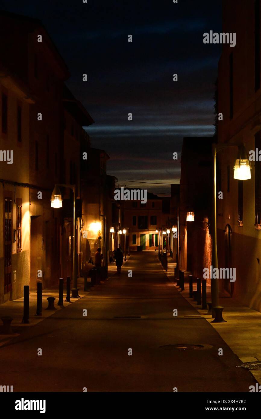 nighttime street scene with warm lantern light illuminating the quiet ...